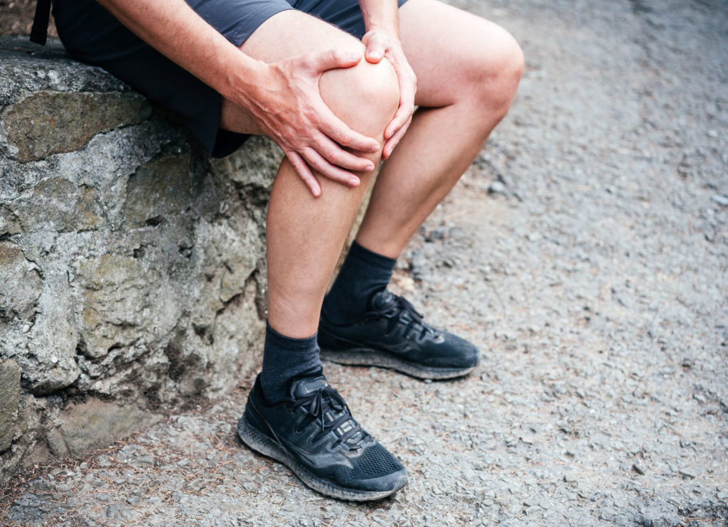 A man athlete suffering from knee pain through patellofemoral pain ...